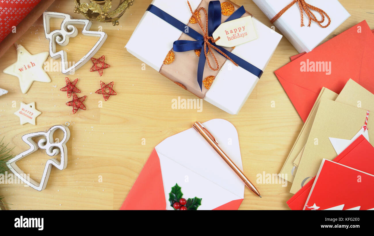 Wrapping gifts and writing Christmas cards overhead Stock Photo - Alamy