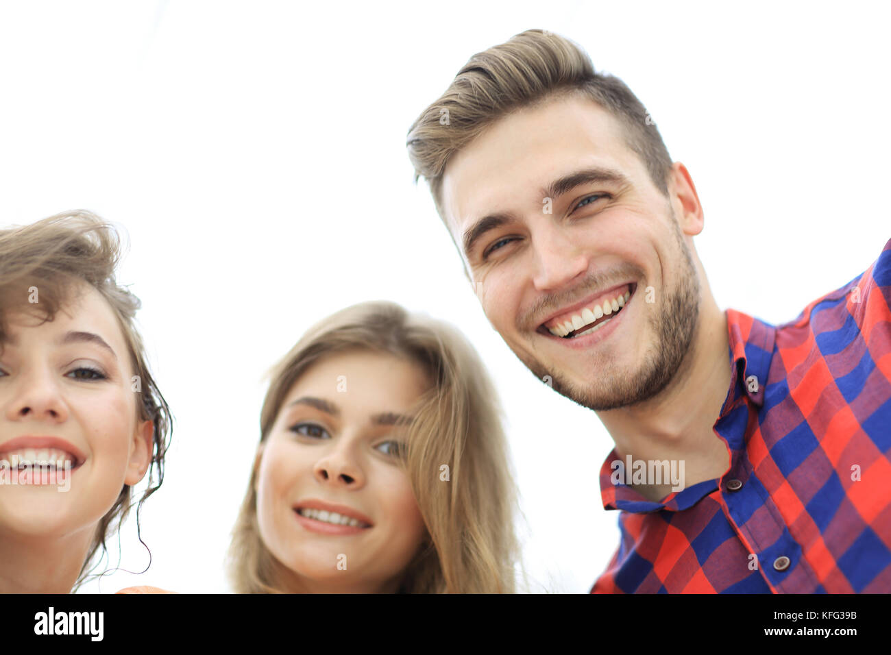 closeup of three happy young people smiling over white background Stock ...