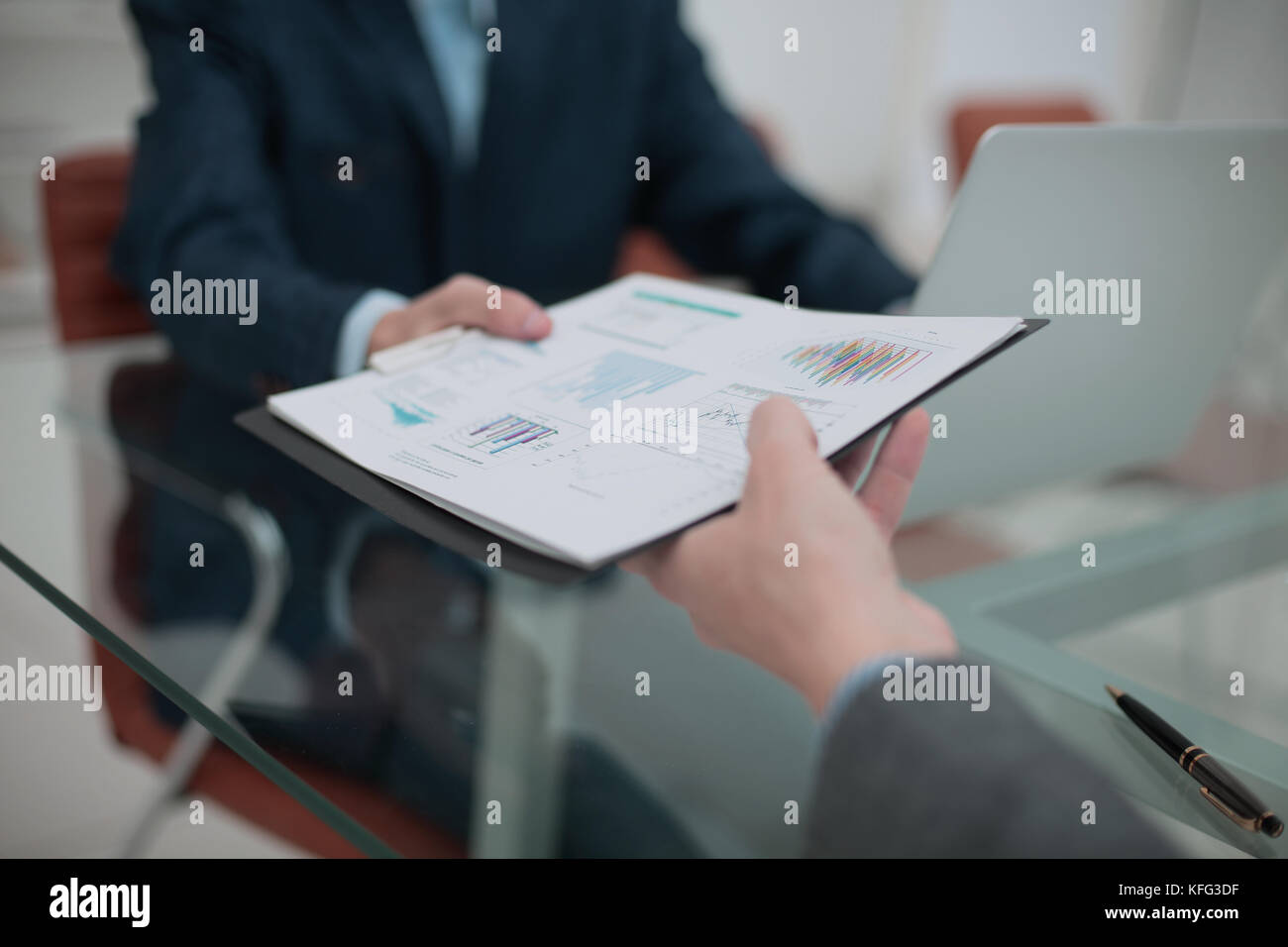 Businessman giving document to his colleague at meeting Stock Photo - Alamy