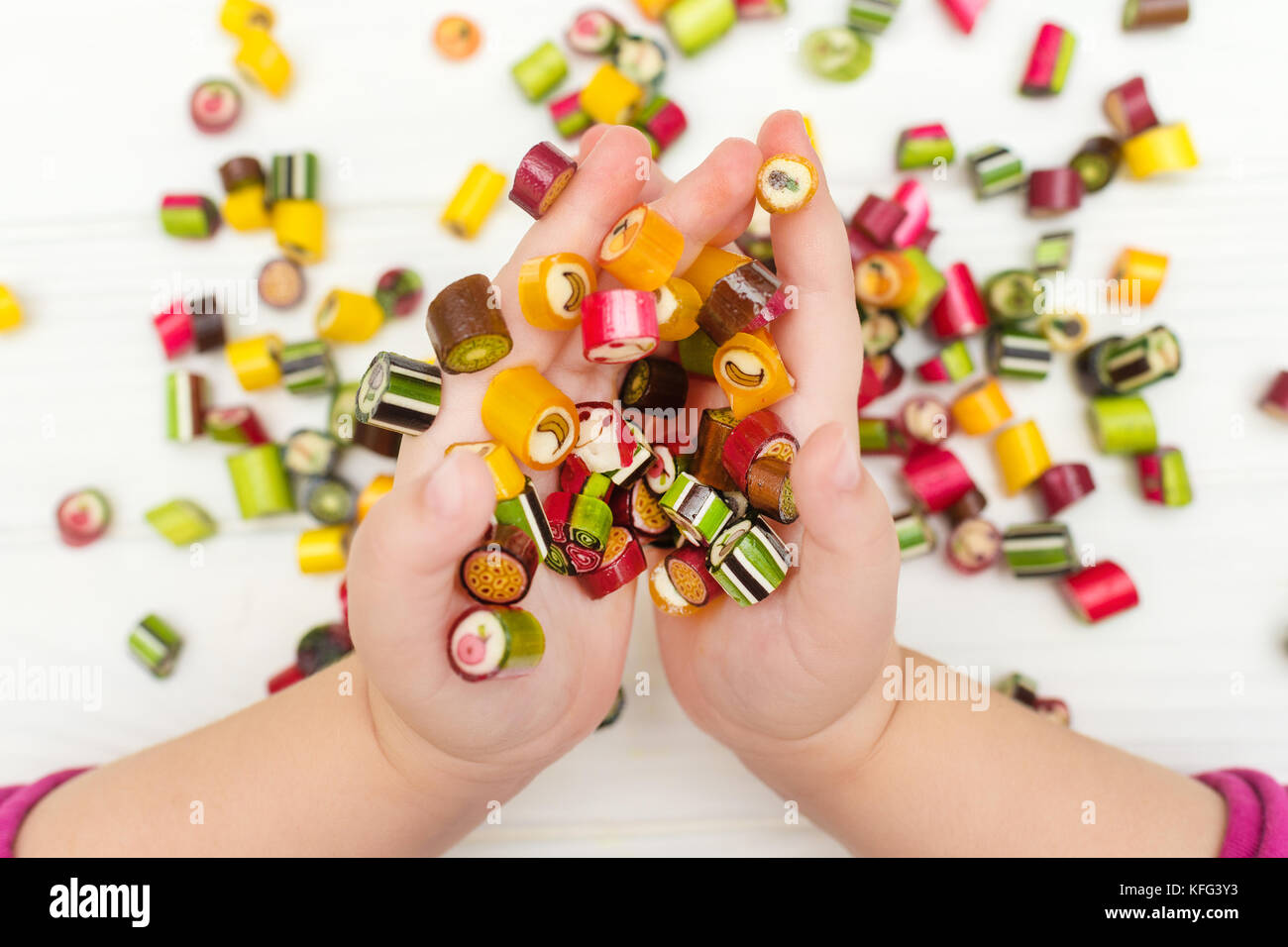 A colored caramel candies in child hands Stock Photo - Alamy