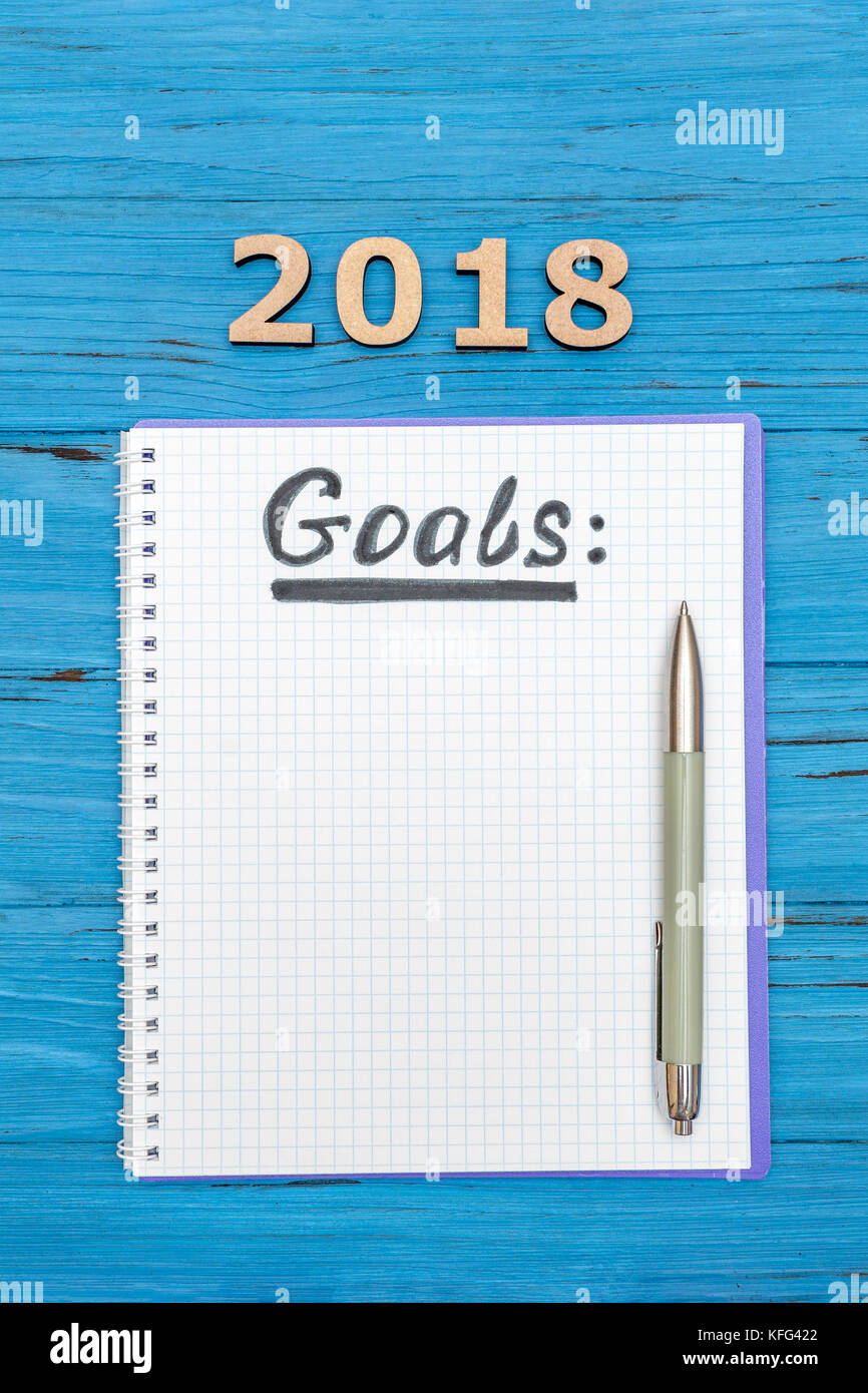 Notebook with new years goals for 2018 with a pen and numbers 2018 on a ...