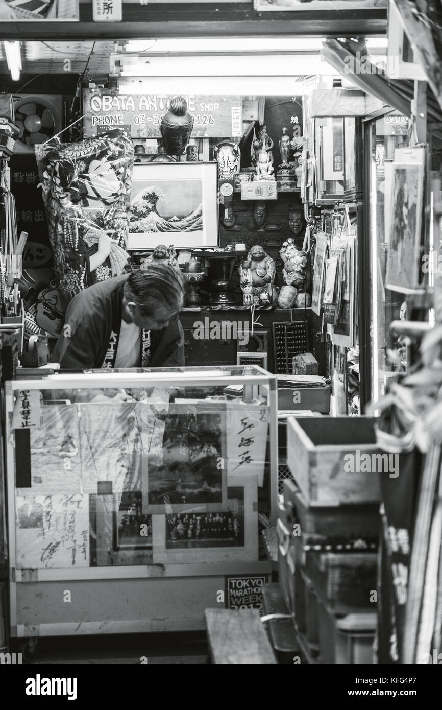 An elderly man standing behind the counter of his small art store Stock ...