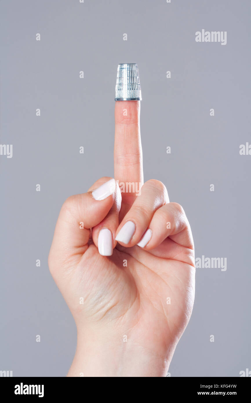 Hand with a Thimble on Middle Finger on Grey Background Stock Photo - Alamy