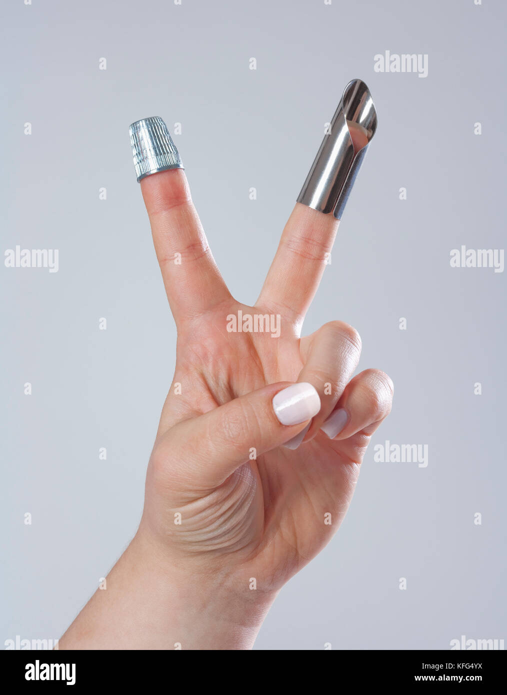 Hand with Two Thimbles on Fingers on Grey Background Stock Photo - Alamy