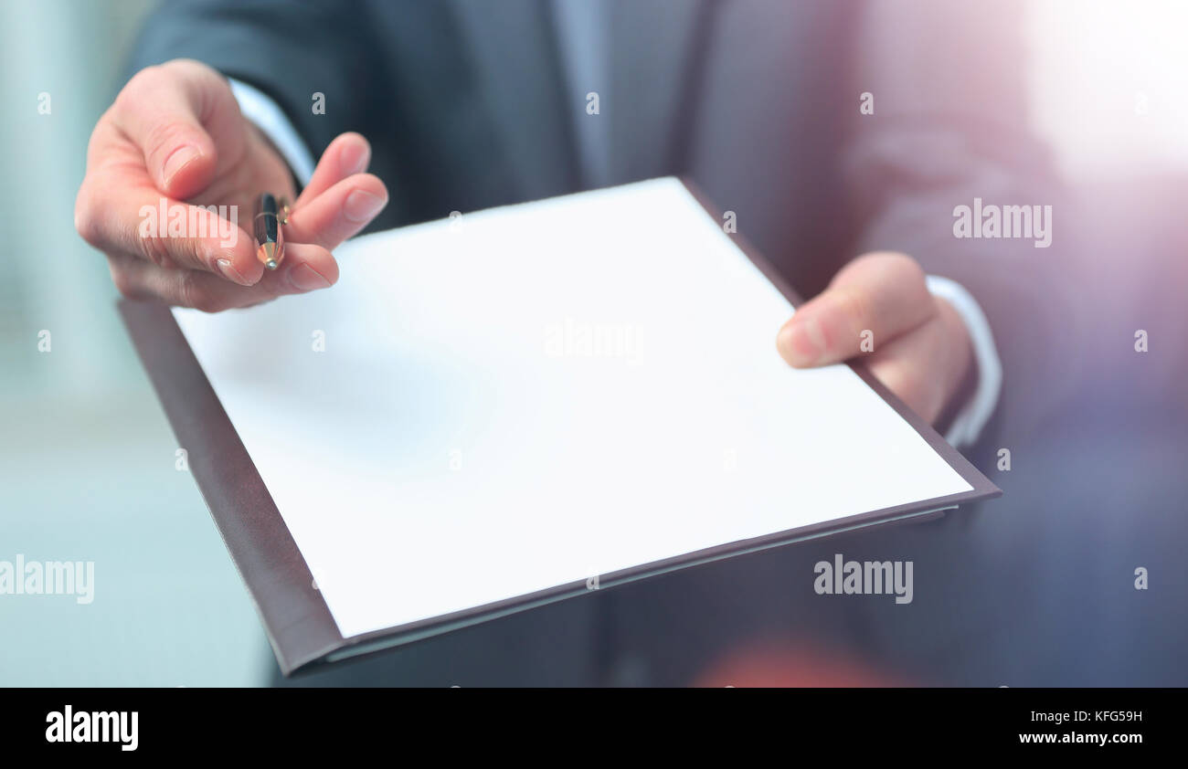 Businessman giving pen for your signature on clipboard Stock Photo - Alamy