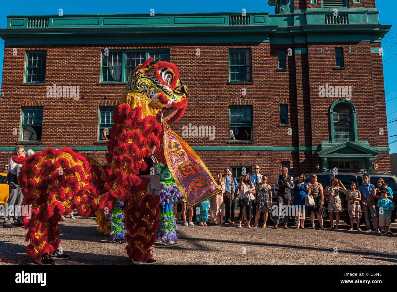 Chinese dragon in street parade. Crowd of people stand outside by old ...