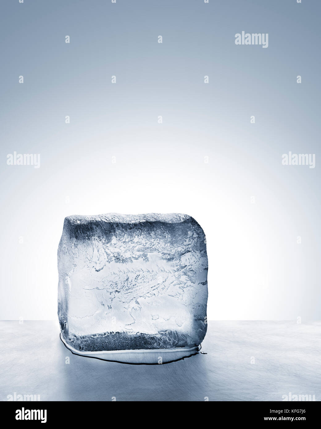 Frosty translucent, frigid cold blue ice block melting to create pool ...