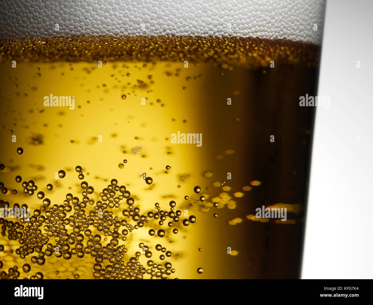 Closeup of freshly poured gold amber beer with frothy head and ...