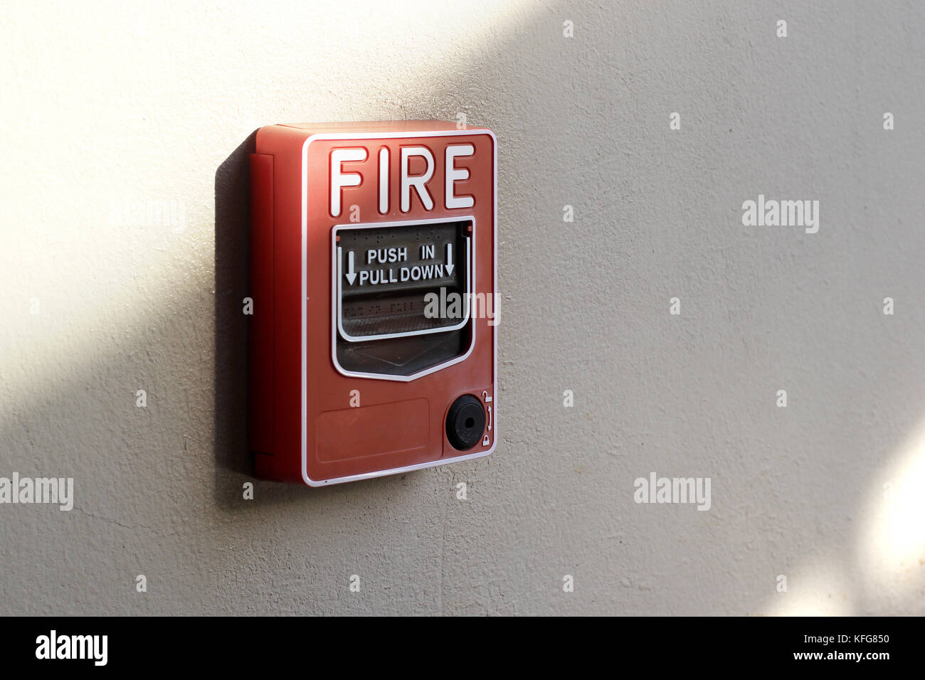 red fire alarm box on cement wall background Stock Photo - Alamy