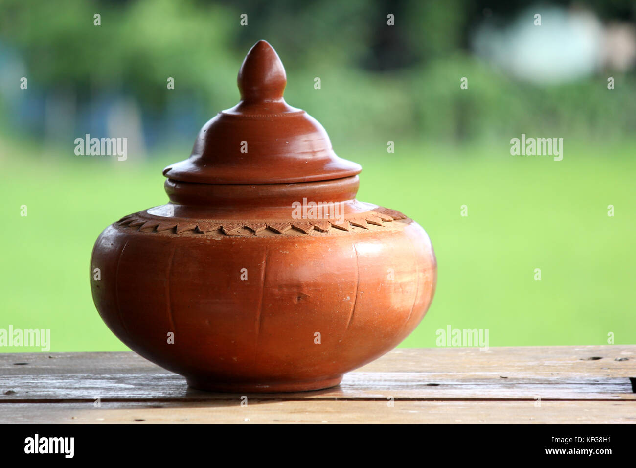 handmade clay pot with lid on wooden table Stock Photo - Alamy