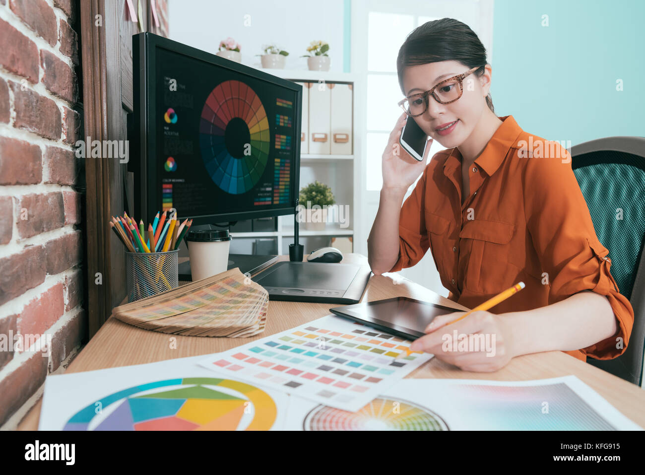 happy beautiful female graphic designer using mobile smartphone calling ...