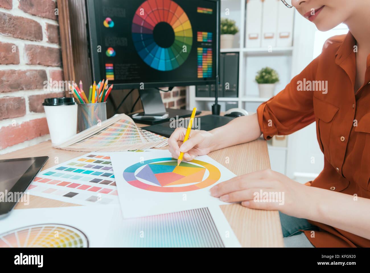smiling elegant woman designer looking at palette chart paper thinking ...