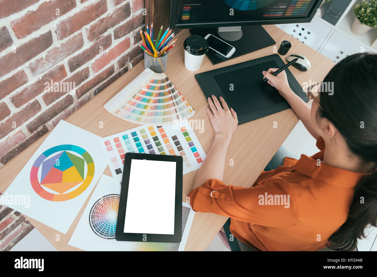 high angle view photo of young attractive female graphic designer using ...