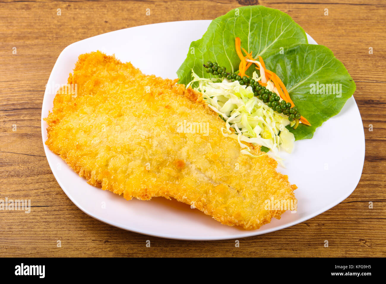 Fried Dory fish with salad on the wood background Stock Photo - Alamy