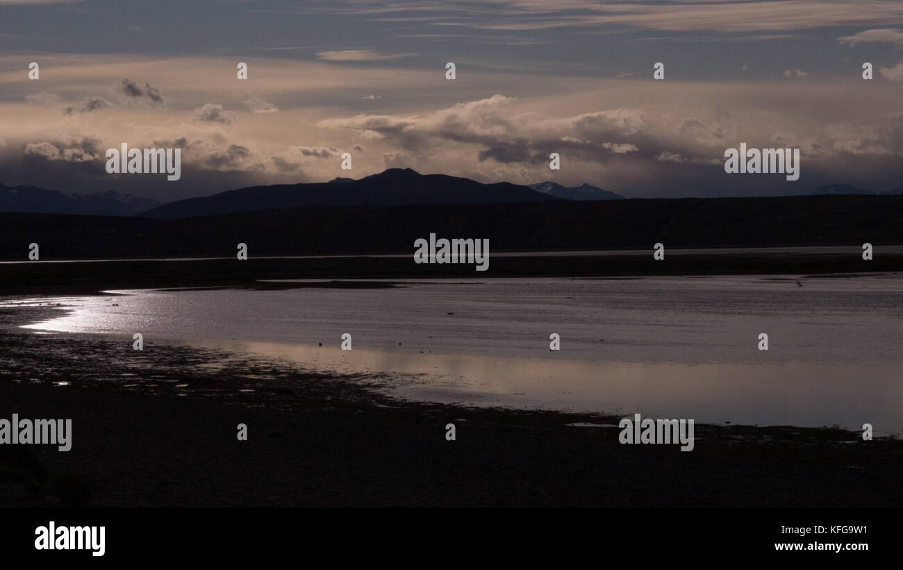 Dramatic shadows cast across mountain range with beginning of rainbow ...