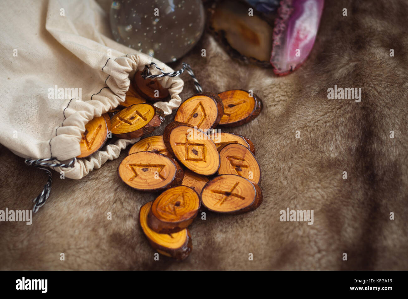 wood runes handmade fur are lying beside the crystal ball and semi ...