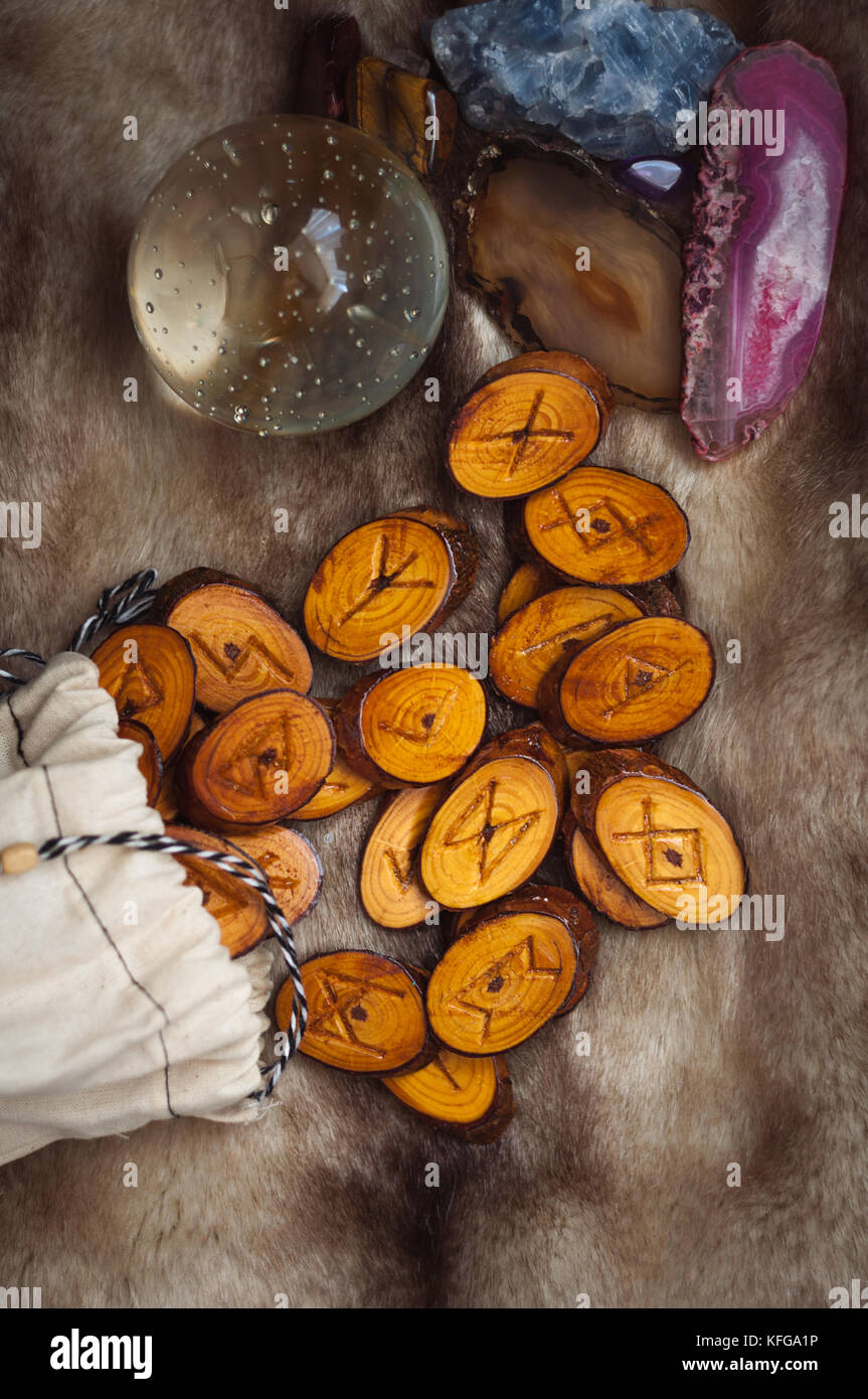 wood runes handmade fur are lying beside the crystal ball and semi ...