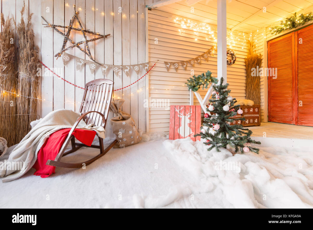 Christmas morning. Rocking chair with decorations by firewood and ...