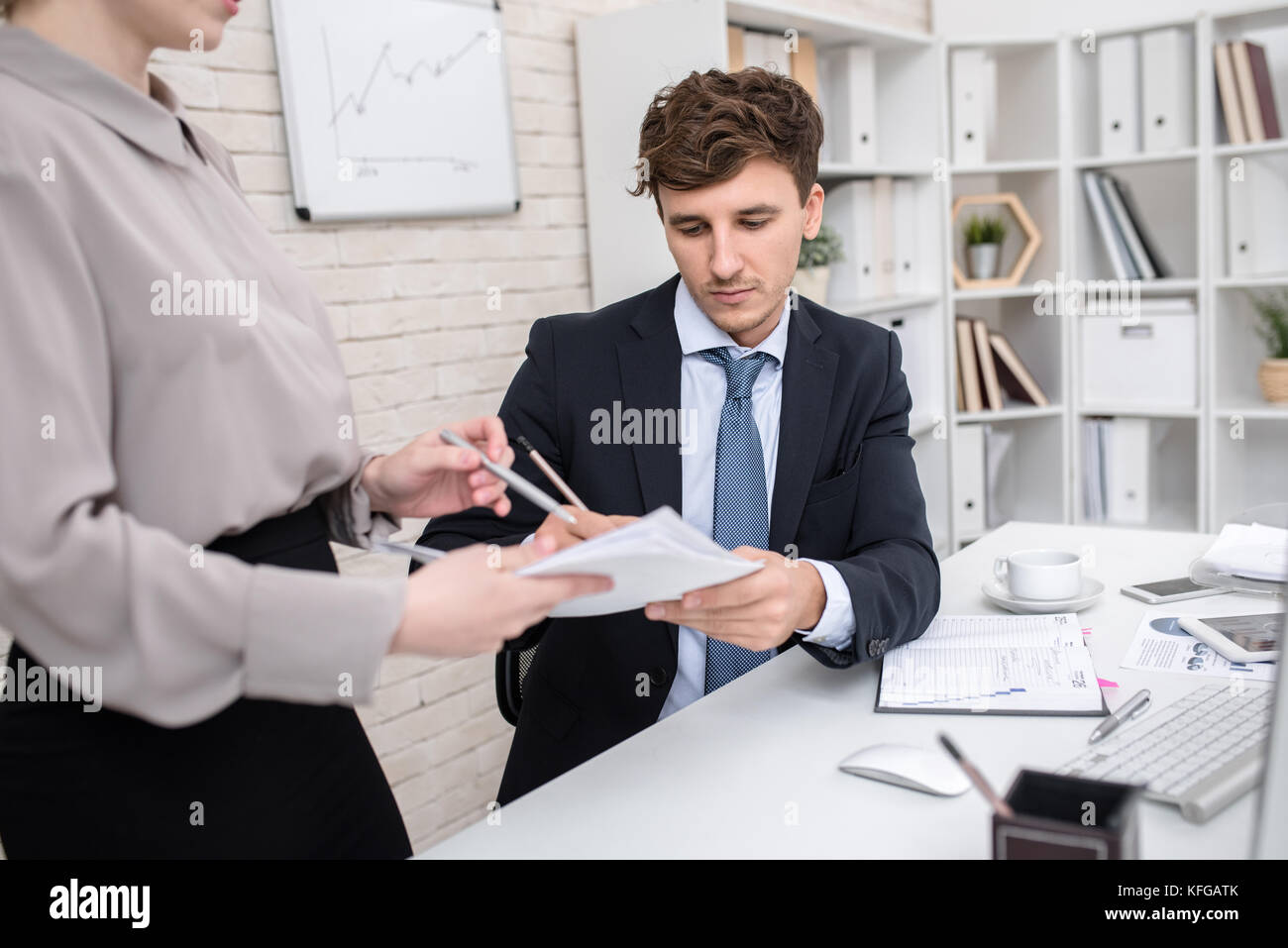 Businessman Signing Documents at Desk Stock Photo - Alamy