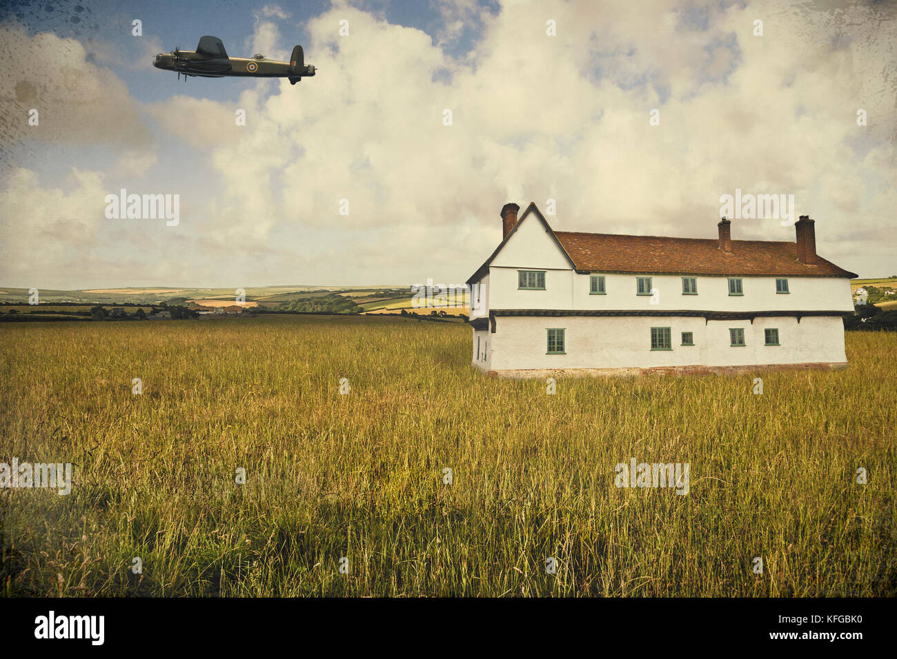 WWII Lancaster bomber flying low over a historic farmhouse, set in a ...