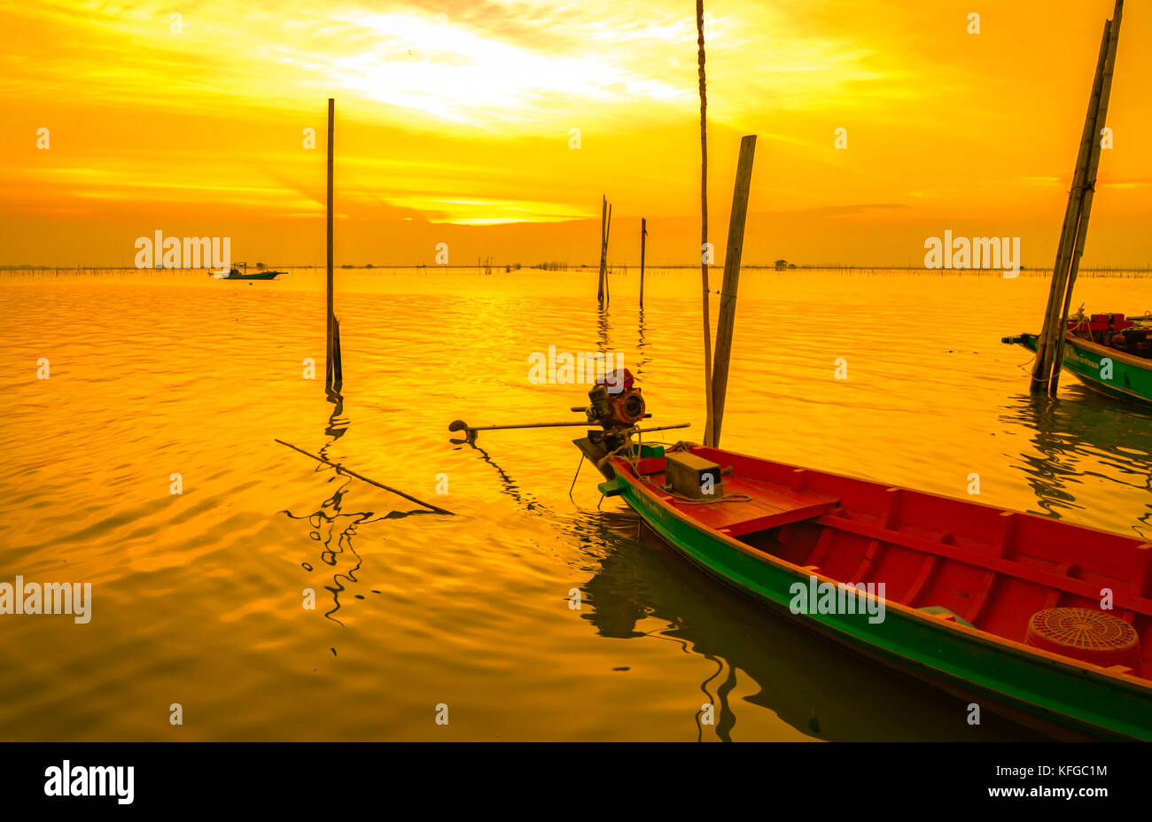 Fisherman's boat floating in the sea near bamboo pole at sunset in ...