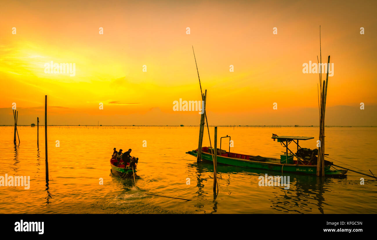 Fisherman's boat floating in the sea near bamboo pole at sunset in ...