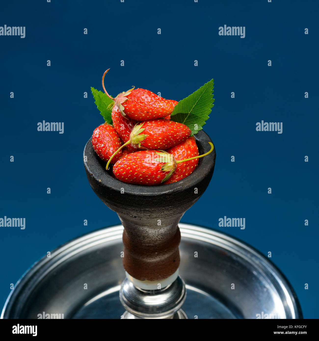 Smoking hookah with fruit head on blue background Stock Photo - Alamy