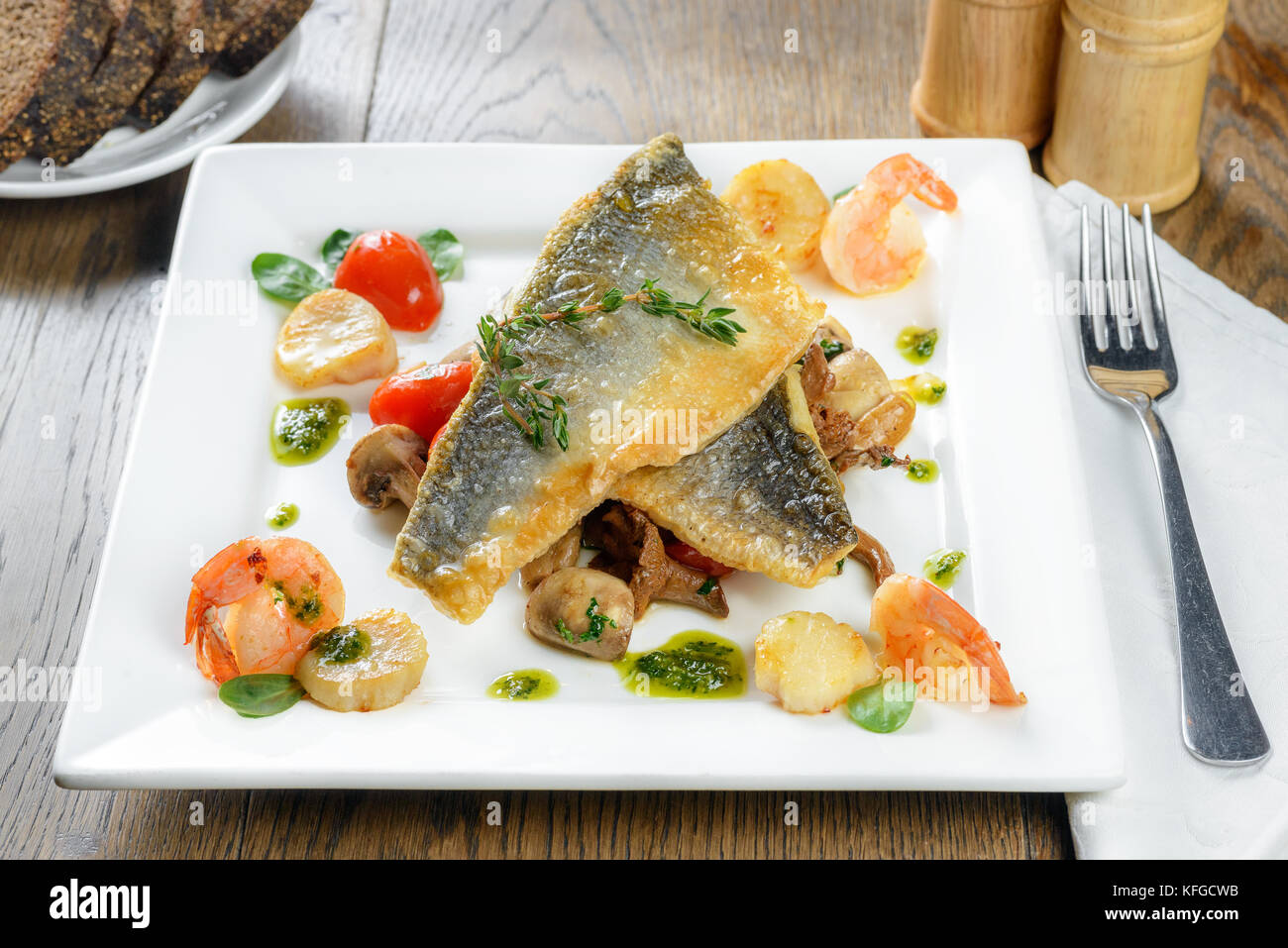Fried fish garnished with seafood in Asian style Stock Photo - Alamy