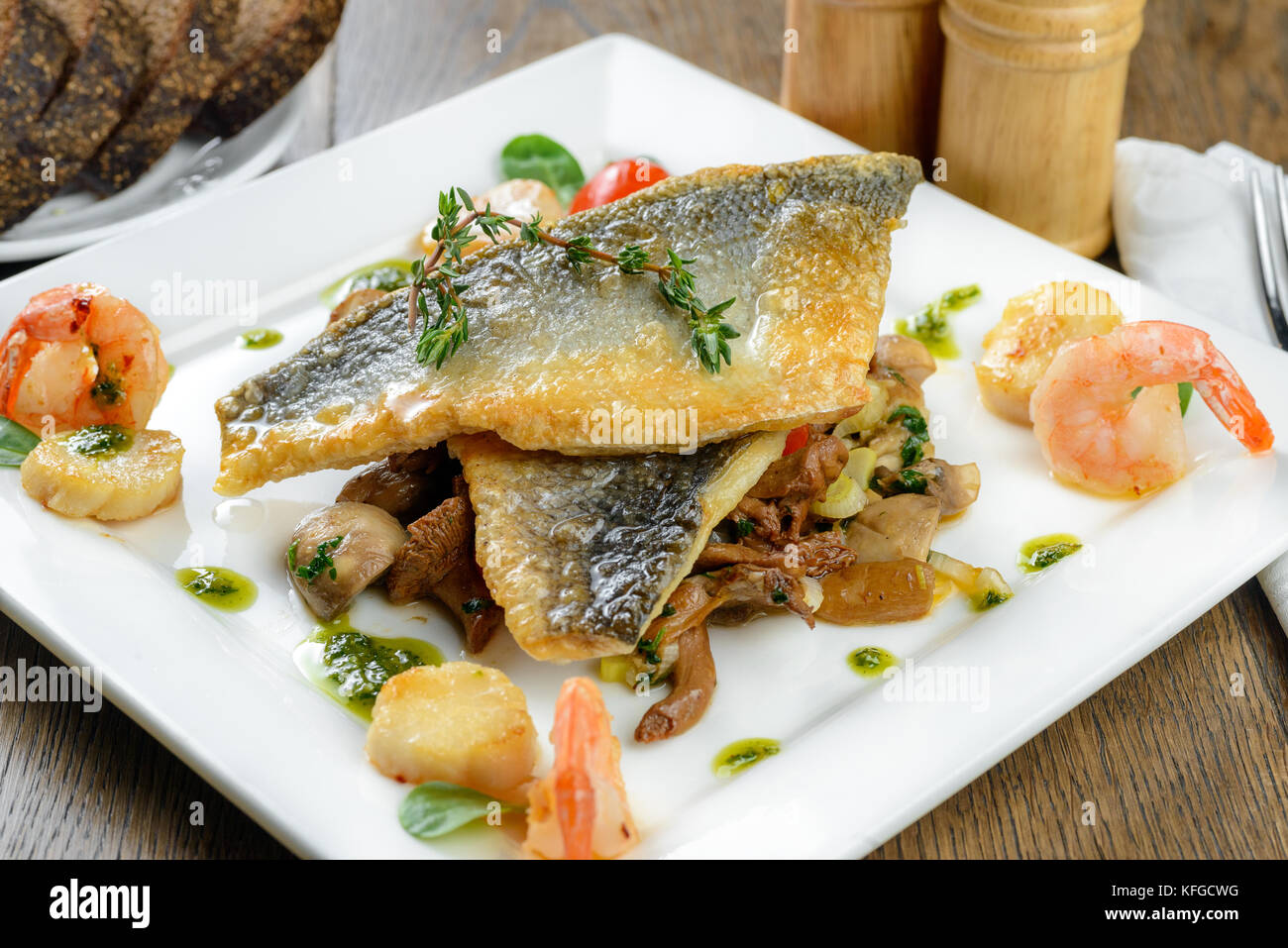 Fried fish garnished with seafood in Asian style Stock Photo - Alamy