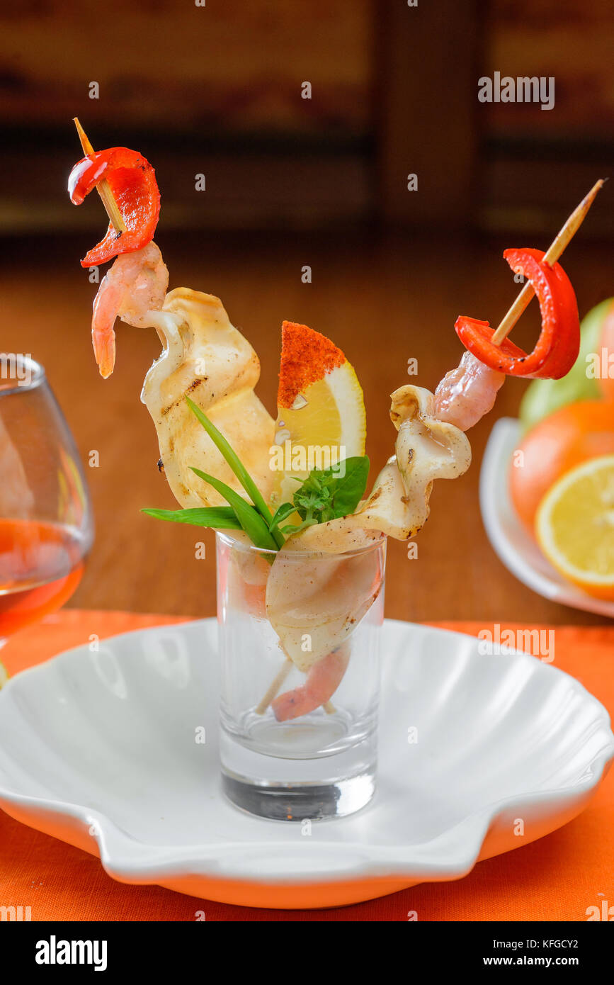 Grilled seafood on sticks in decorative shell dish Stock Photo - Alamy