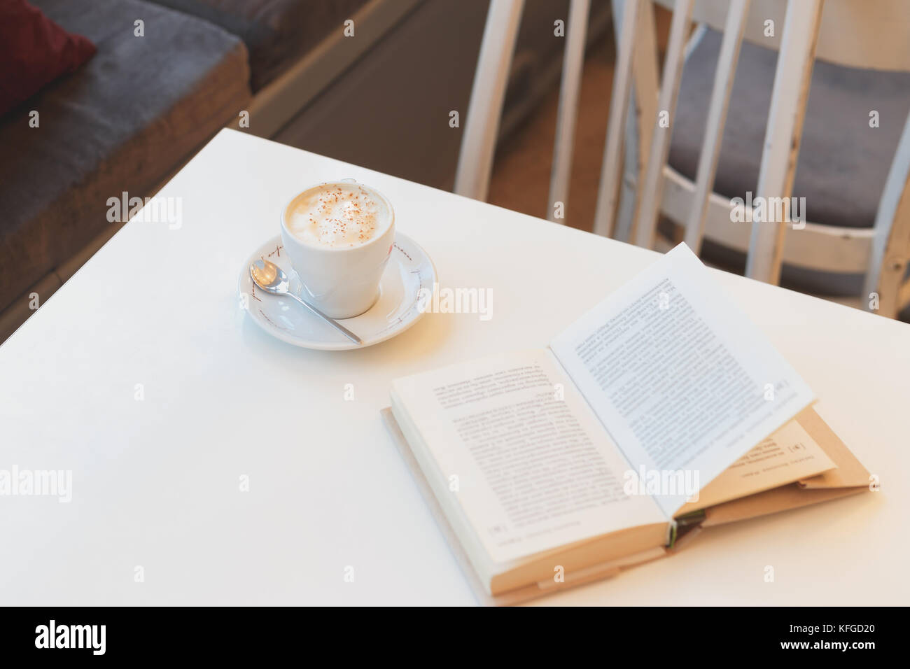 Book on white free table with cup of coffee in cafe Stock Photo - Alamy