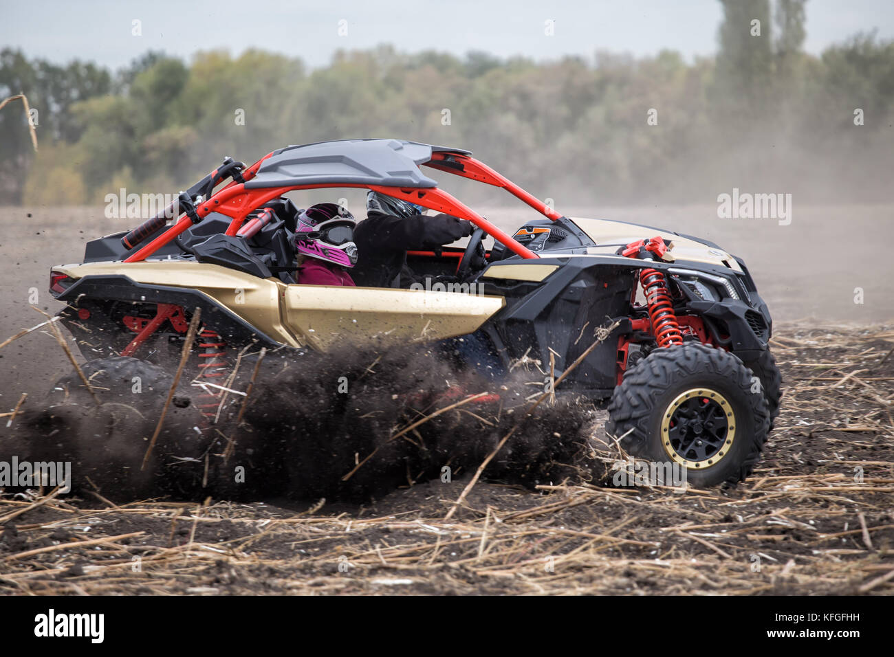 Two pilots in the cockpit of quad bike rushing through the field Stock ...