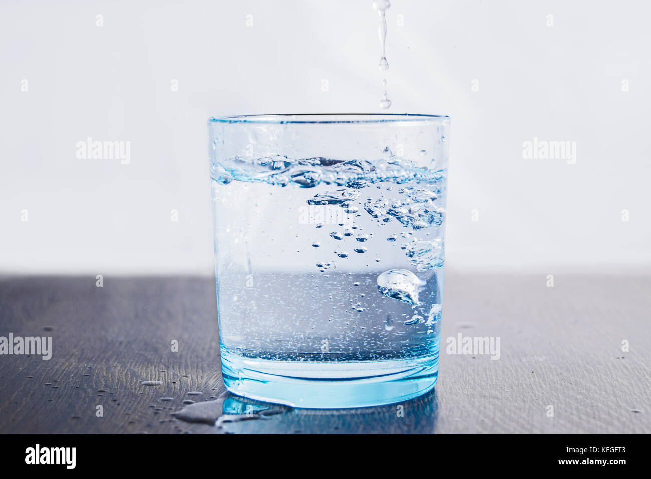 a glass filling of water, in a high key photography with a white bright ...