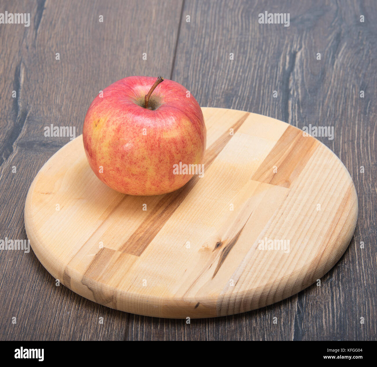 Apple on the round cutting board Stock Photo - Alamy