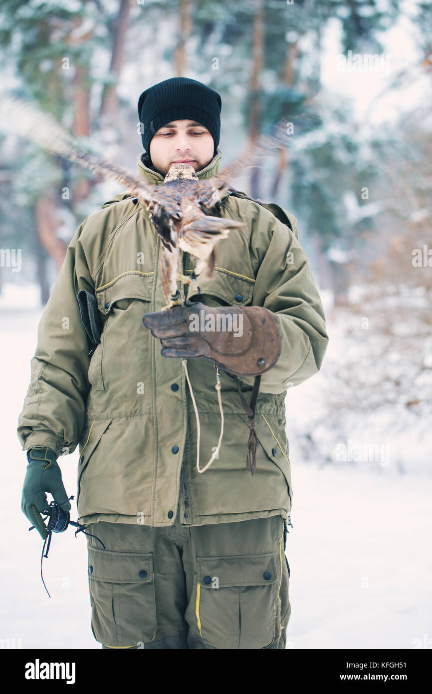 Young handsome man holding a falcon on his arm Stock Photo - Alamy