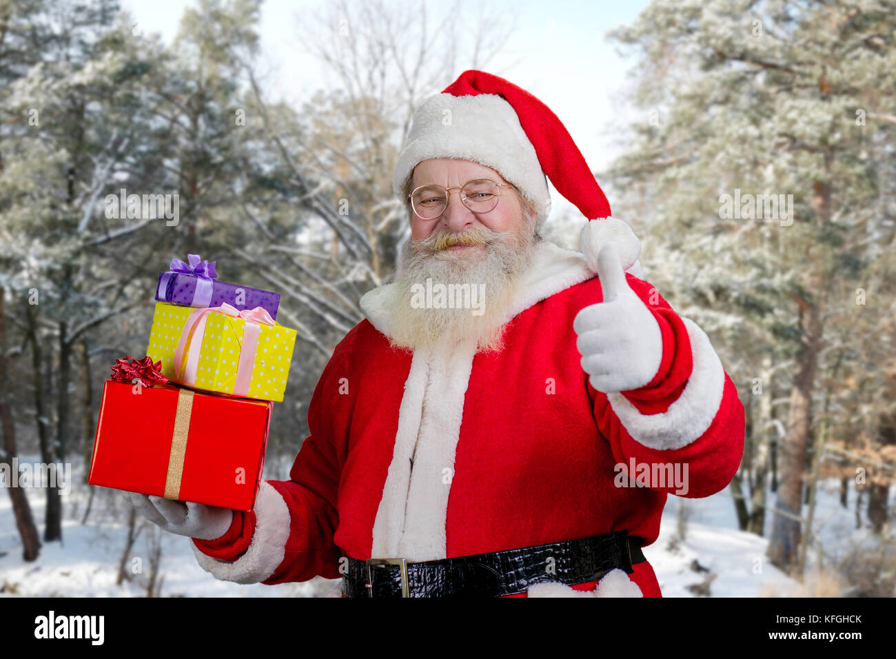Santa Claus with presents outdoors. Santa Claus holding a pile of gift ...