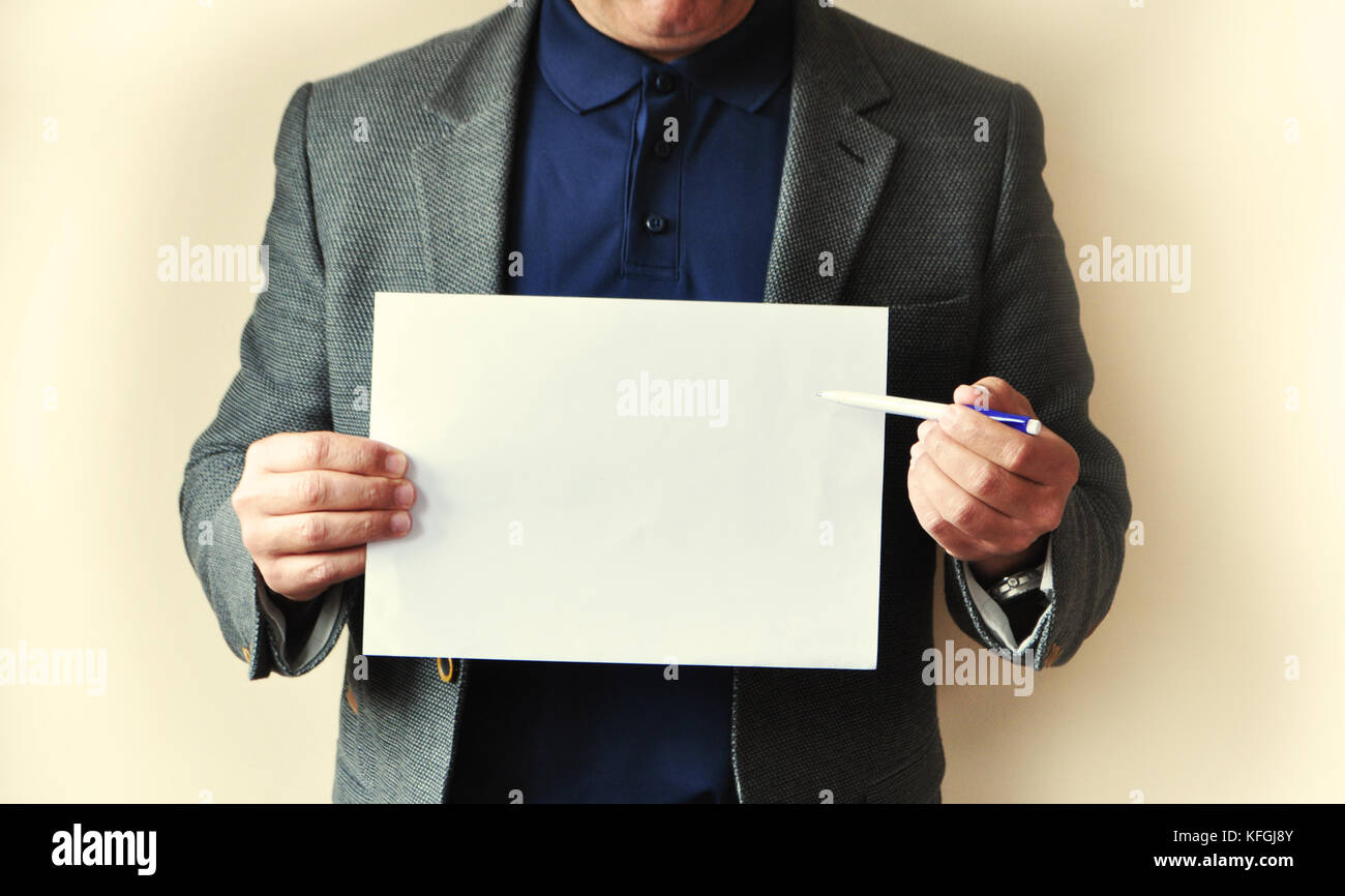 A businessman holding a sheet of white paper Stock Photo - Alamy