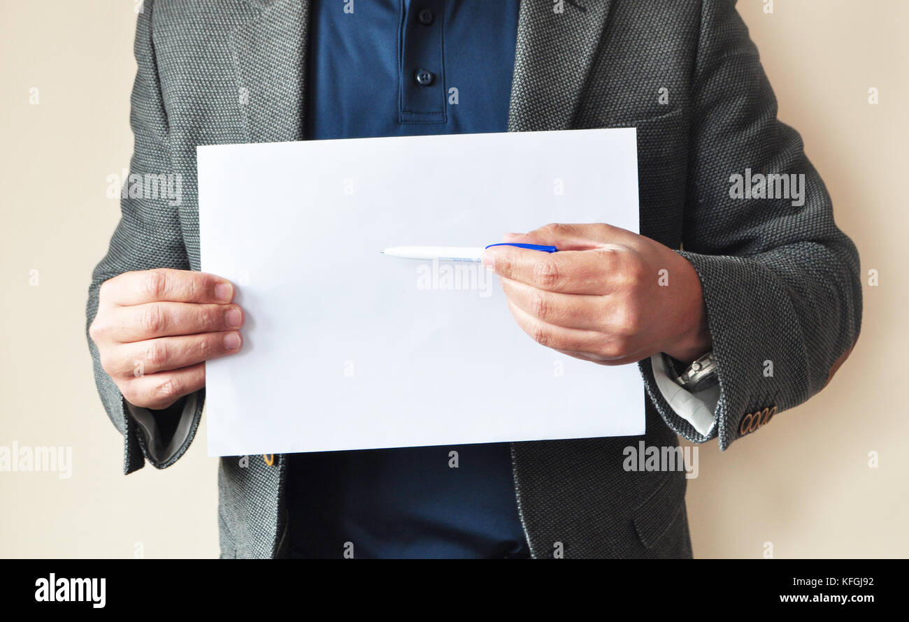 A businessman holding a sheet of white paper Stock Photo - Alamy