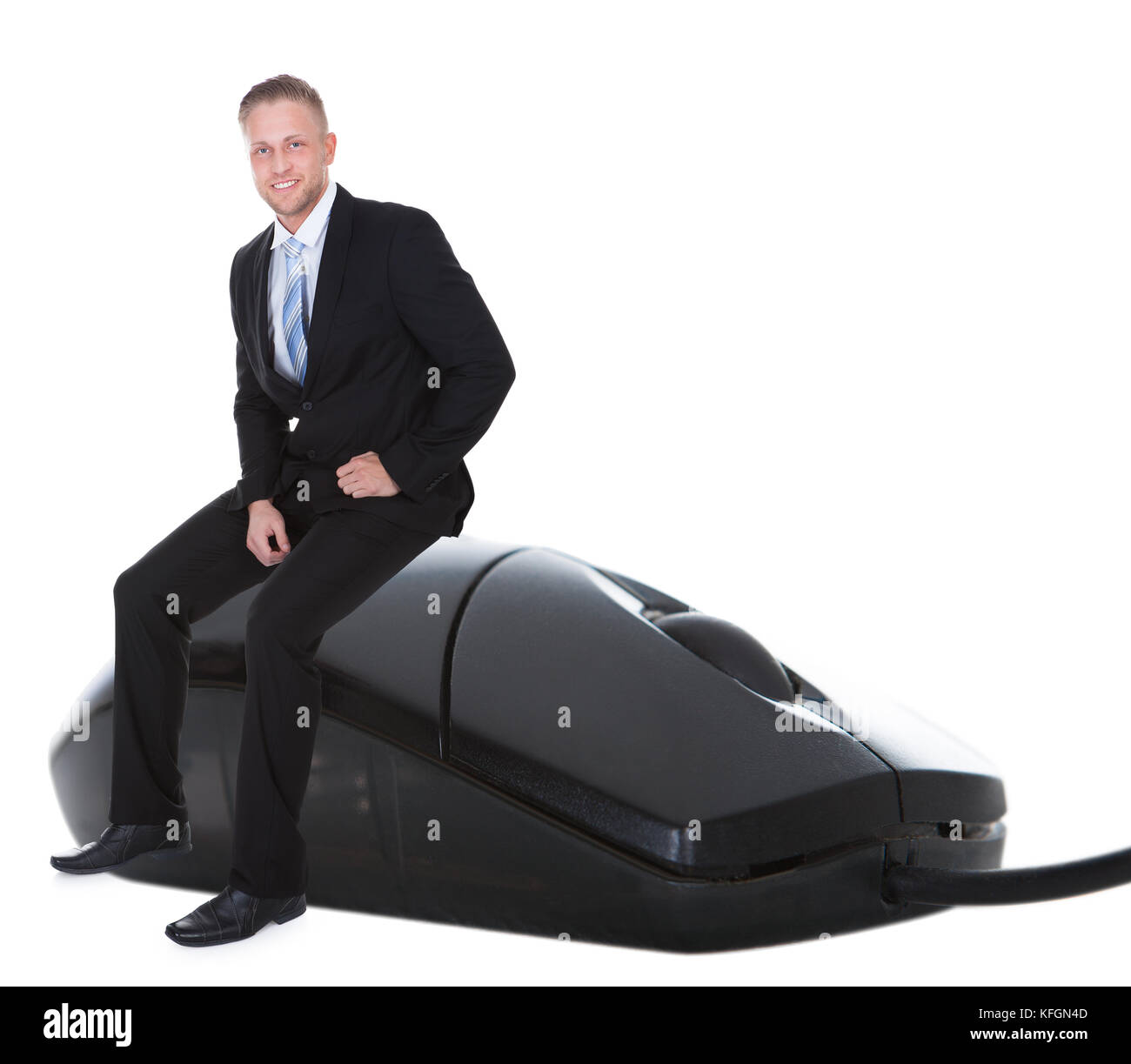 Smiling confident businessman in a suit sitting on a wired computer ...