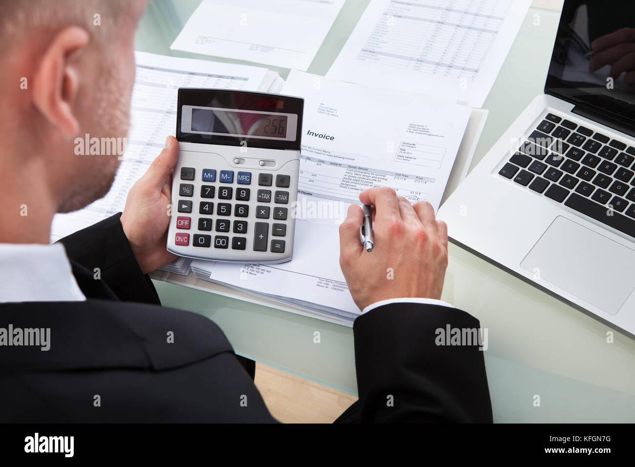 High angle over the shoulder view of a businessman checking figures in ...
