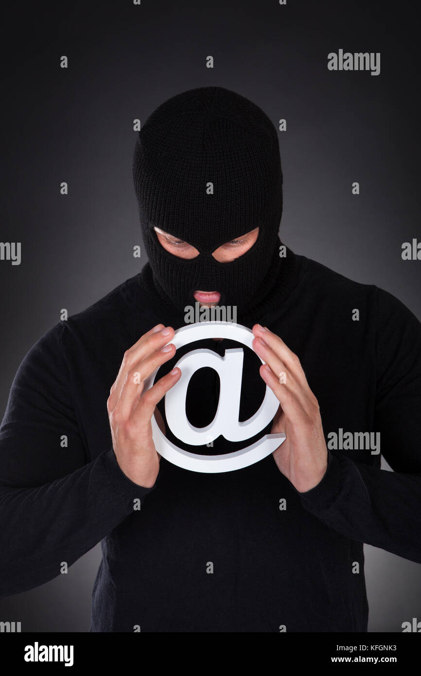 Hacker dressed in black wearing a balaclava with a white internet ...