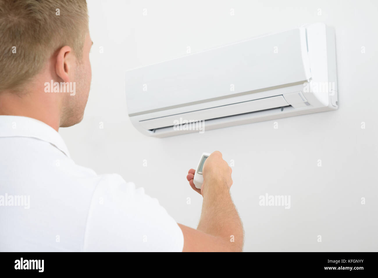 Man Operating Air Conditioner With Remote Controller Stock Photo - Alamy
