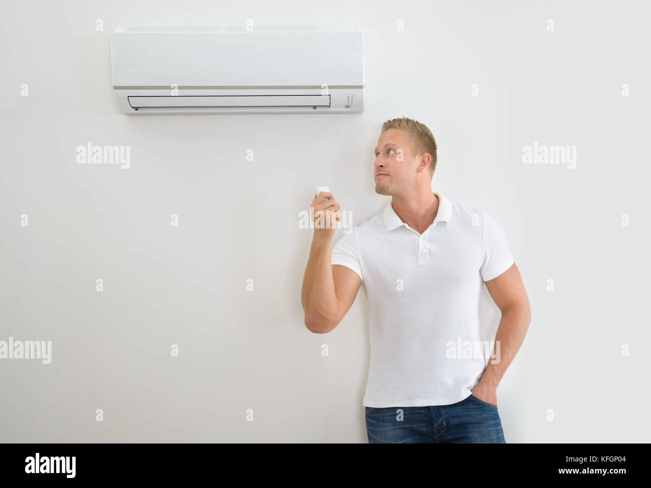 Portrait Of A Man Operating Air Conditioner With Remote Controller ...