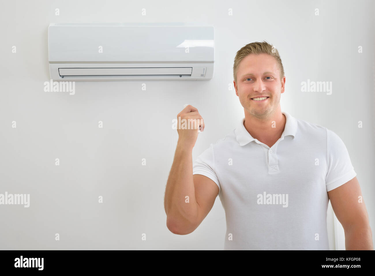 Portrait Of A Man Operating Air Conditioner With Remote Controller ...