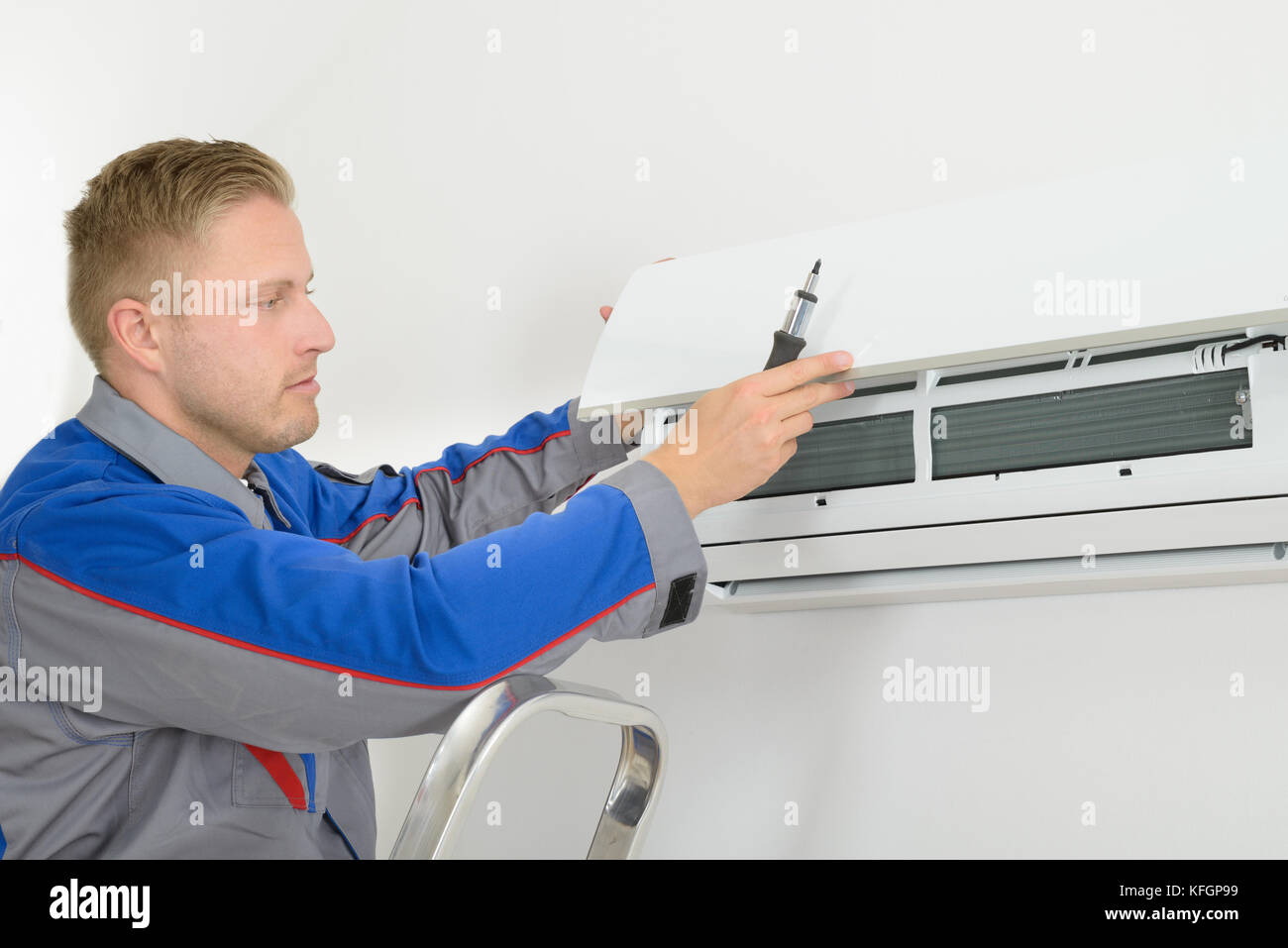 Young Man Repairing Air Conditioner Standing On Stepladder Stock Photo ...