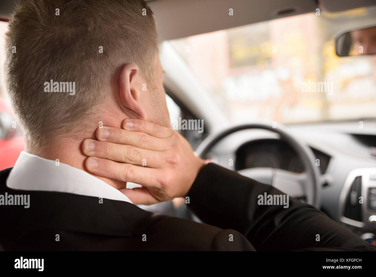 Rear View Of A Man Having Neck Pain While Driving A Car Stock Photo - Alamy