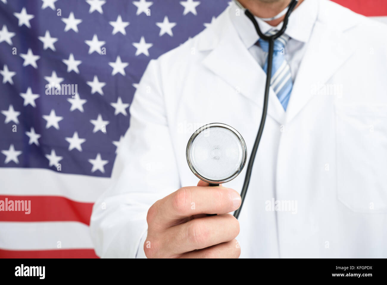 Doctor In Front Of American Flag Holding Stethoscope Stock Photo - Alamy