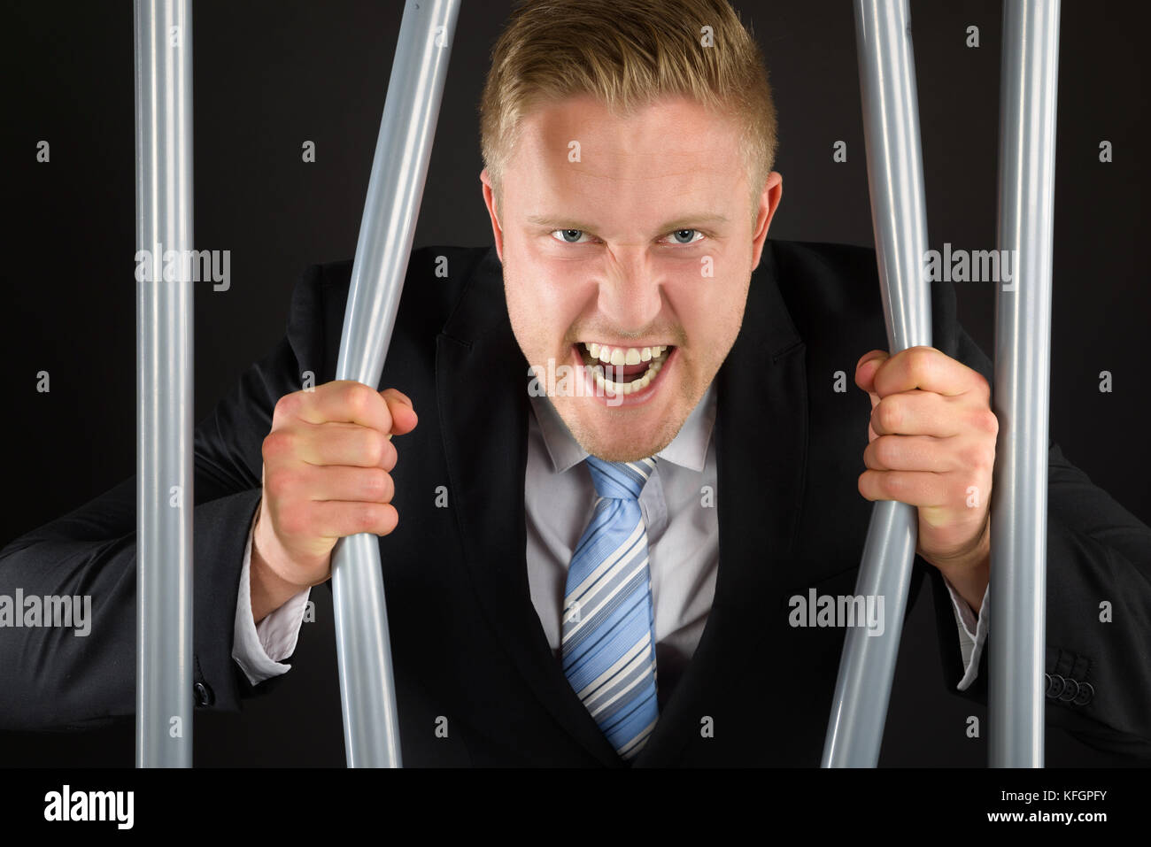 Portrait Of Aggressive Businessman In Jail Bending Bars Stock Photo - Alamy