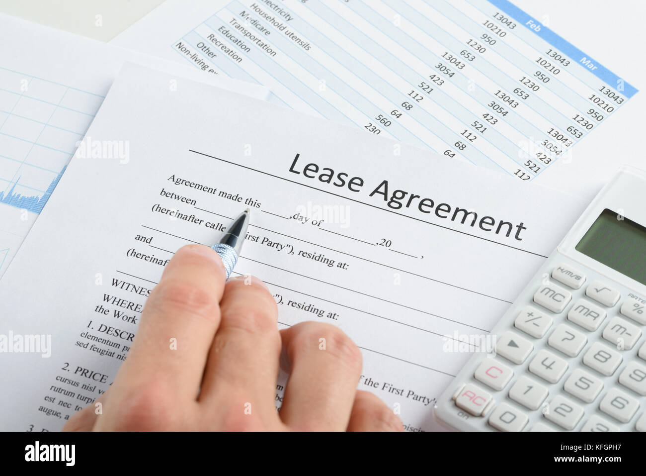 Close-up Of Person Hand With Pen And Calculator Over Lease Agreement ...