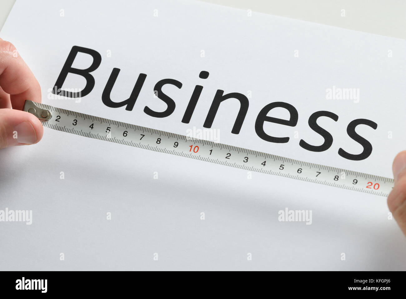 Close-up Of Person Hand Measuring The Text Business With Measure Tape ...